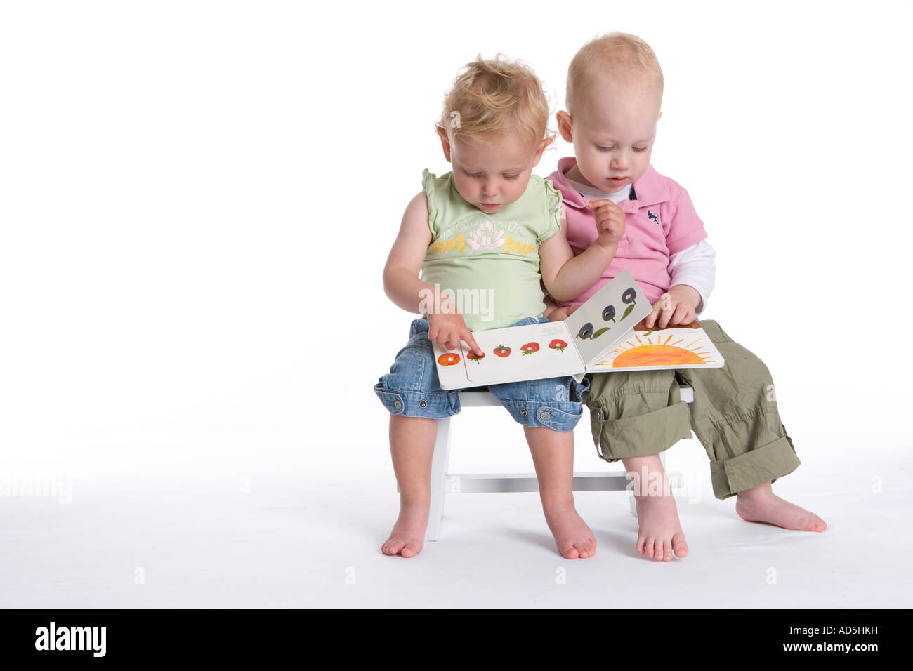 Little boy and girl reading a book together Stock Photo - Alamy