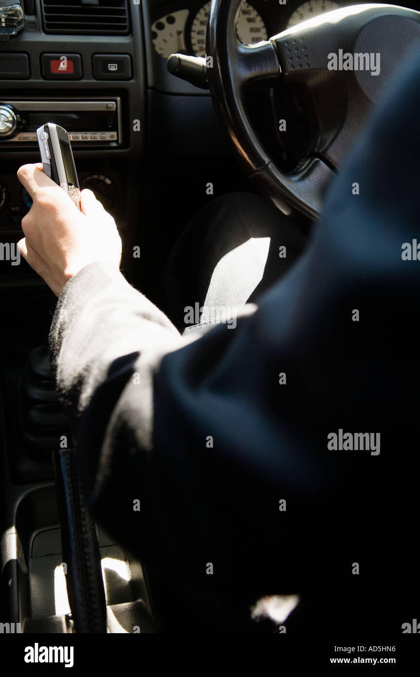 Business person driving a car with mobile phone in hand Stock Photo - Alamy