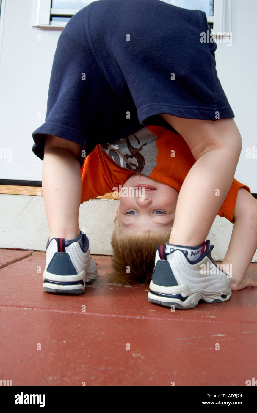Small Child looking through legs upside down playing Stock Photo - Alamy