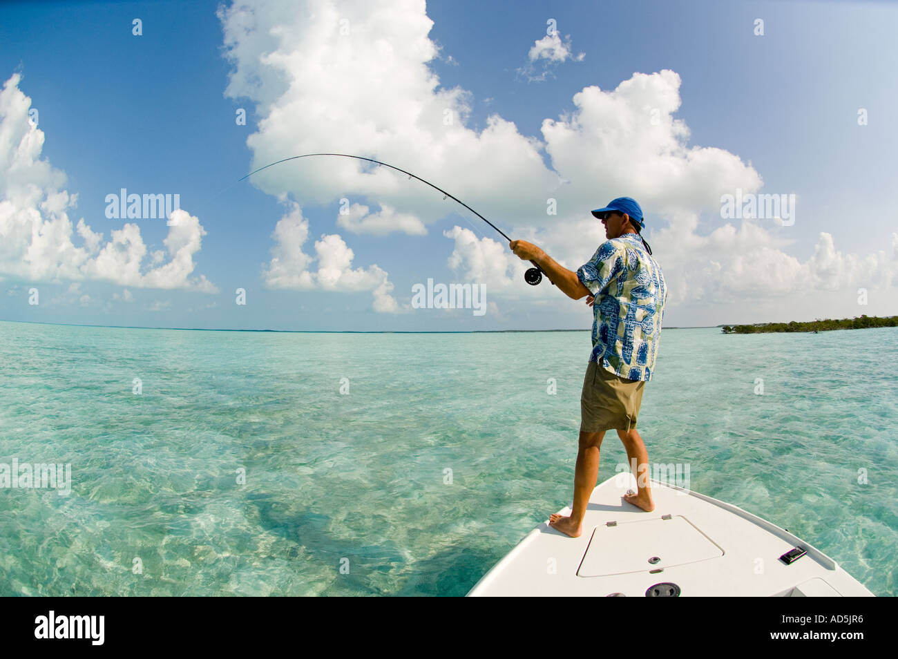 GREATER EXUMA BAHAMAS Fisherman fighting Bonefish on fly rod from ...