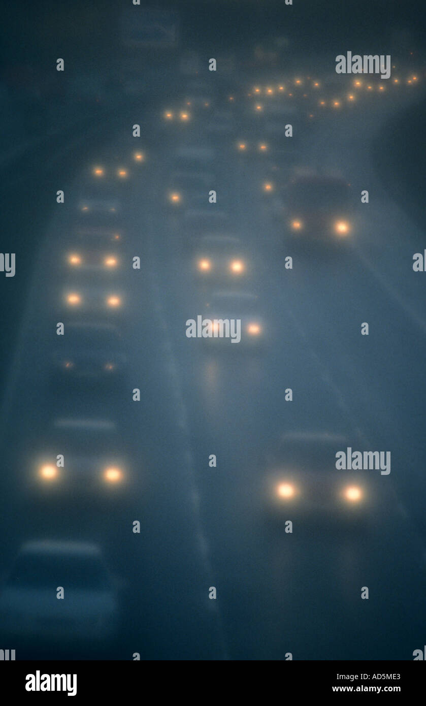 Traffic moving slowly in fog on the M27 motorway in Hampshire England ...