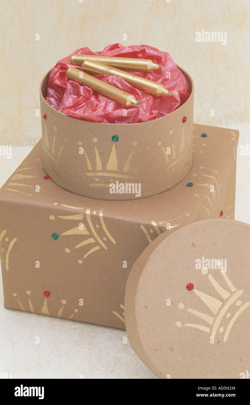 Circular box with gold candles and Christmas present wrapped in gold ...