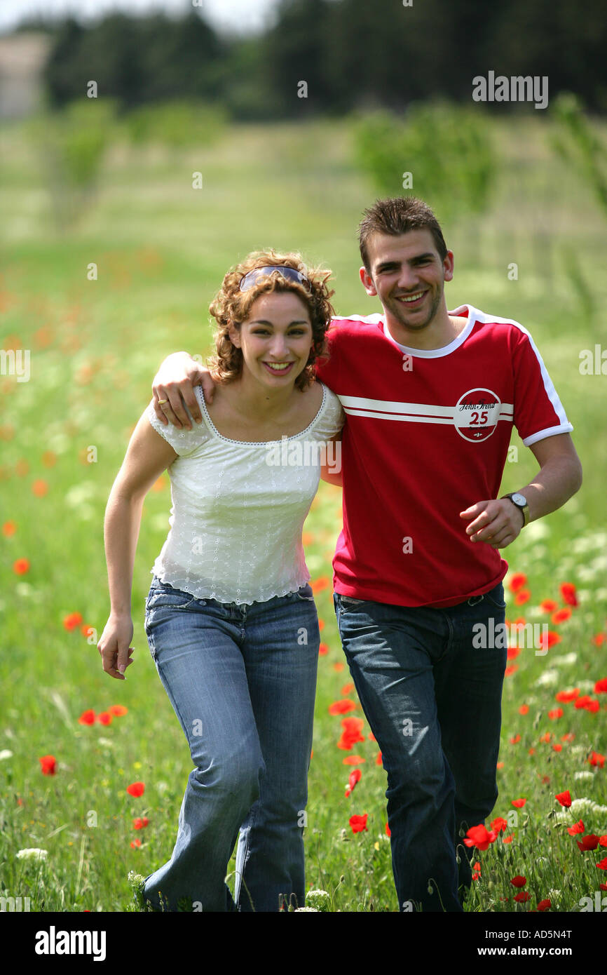 Young couple running in a field of flowers Stock Photo - Alamy