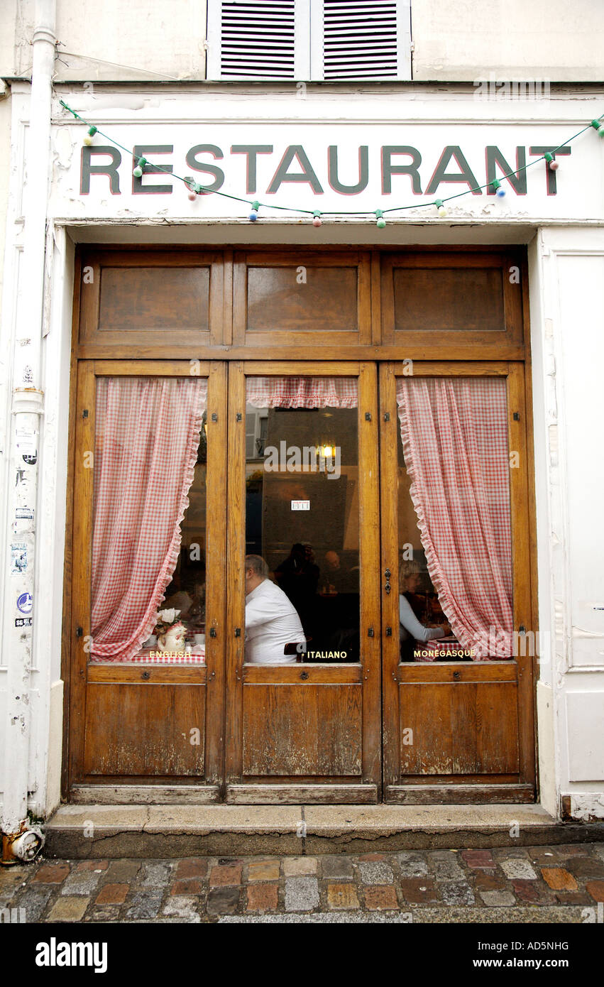 View of people dining in traditional restaurant in Paris with red check ...