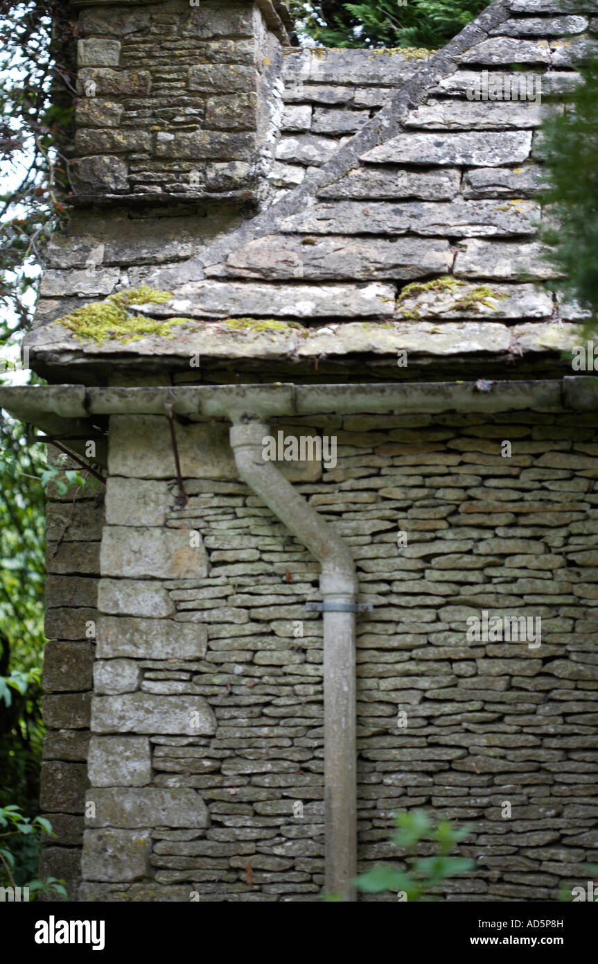 Stone walls with drainpipe and roof slates on old country cottage Stock ...