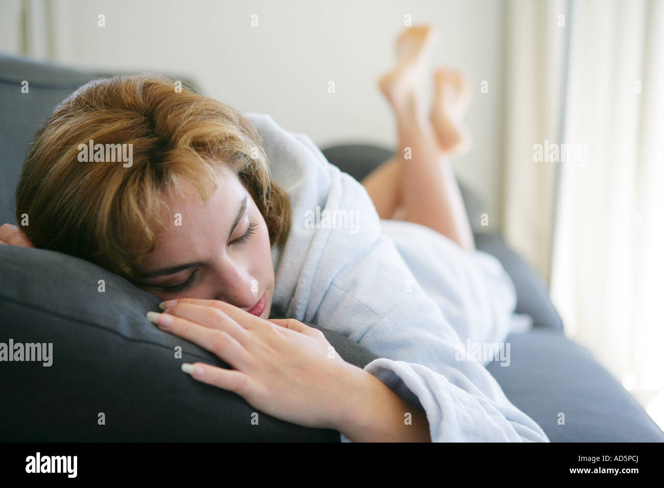 Woman resting on a sofa Stock Photo - Alamy