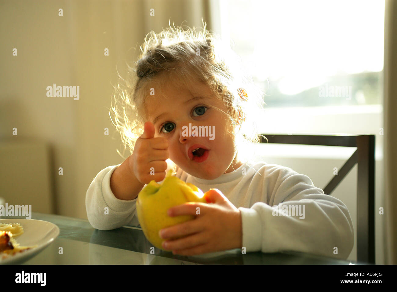 Little girl eating an apple Stock Photo - Alamy