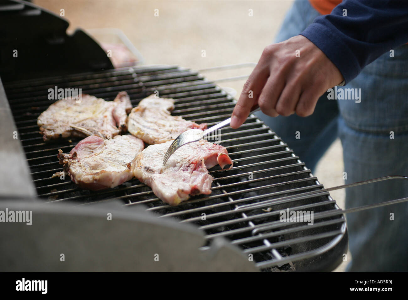 Man preparing steaks on a grill Stock Photo - Alamy