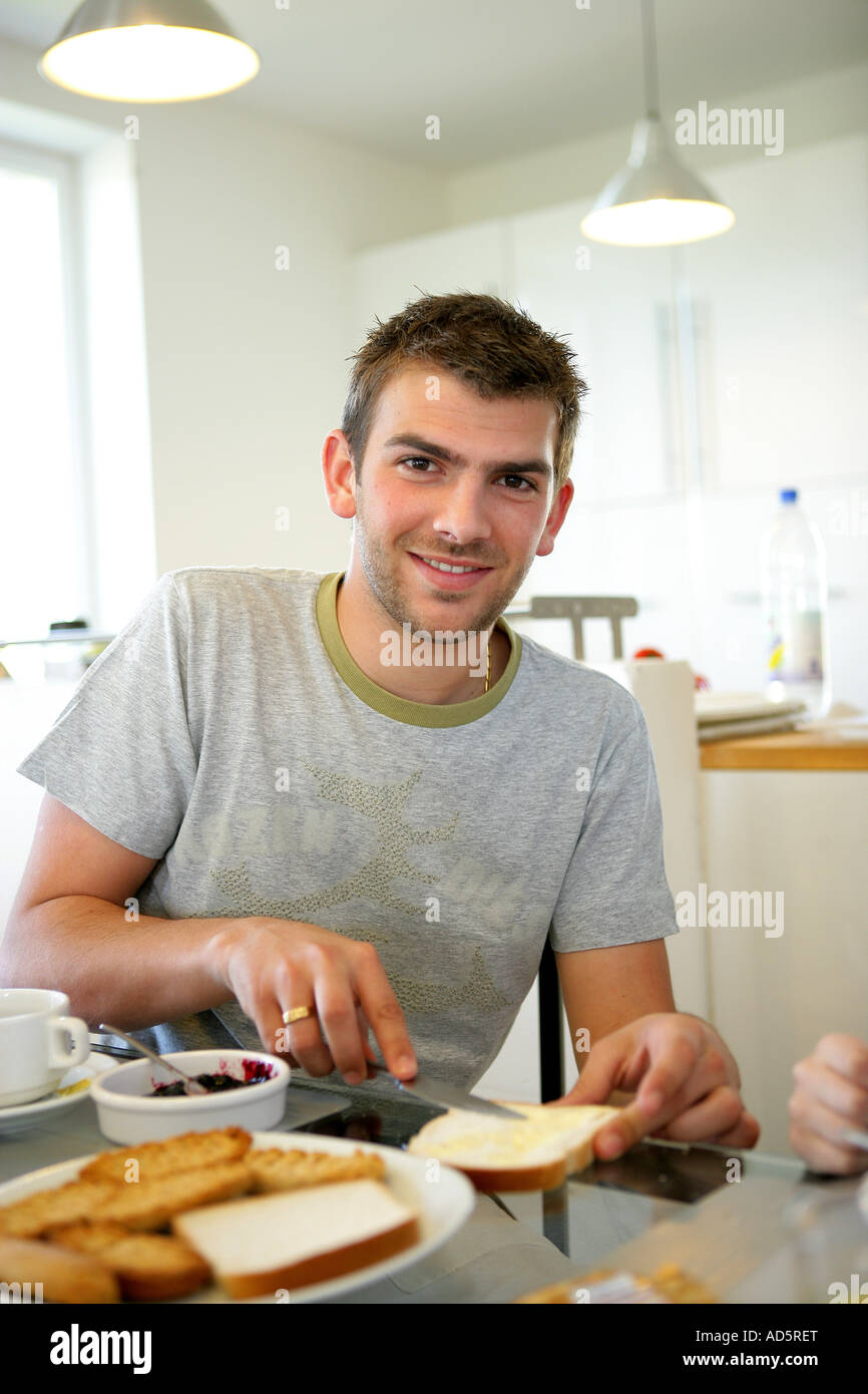 Young man having breakfast Stock Photo - Alamy