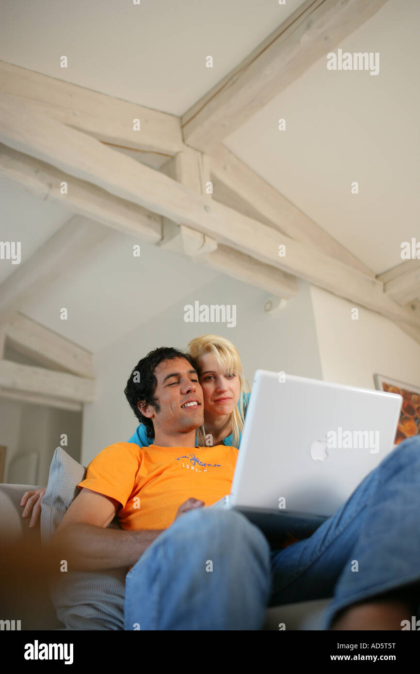 Couple laying on a couch with laptop computer Stock Photo - Alamy