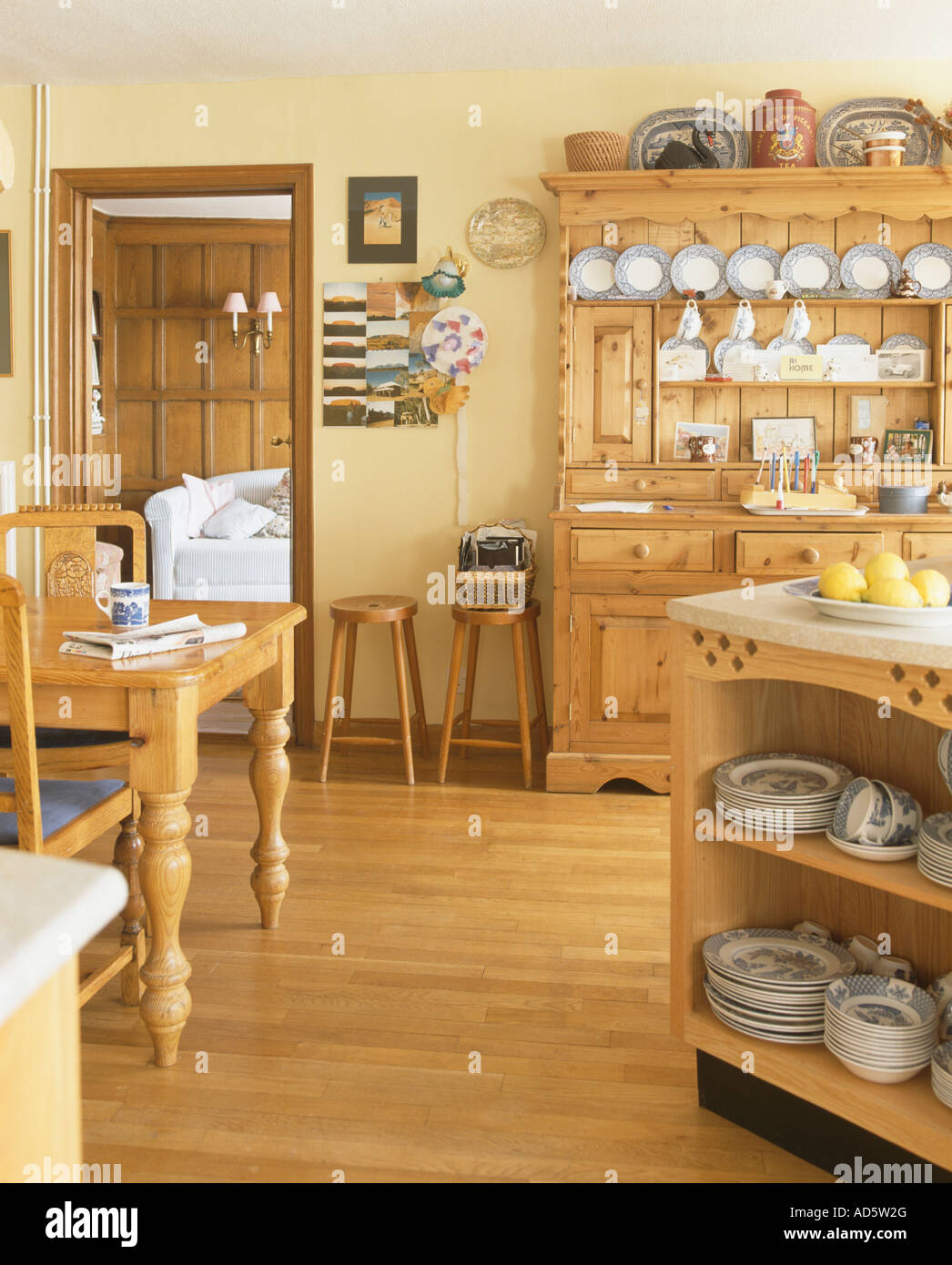 Country kitchen with pine dresser and table and polished wood floor ...