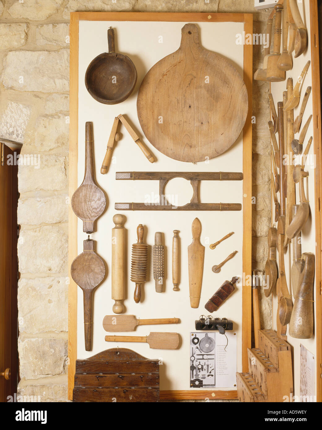Collection of antique wooden kitchen utensils displayed on wall Stock ...