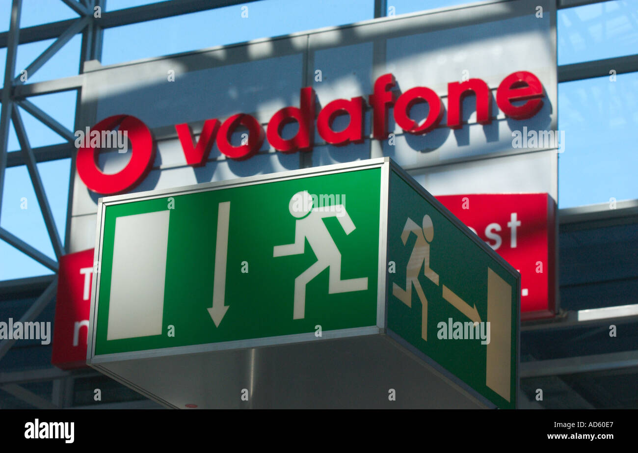 Escape route sign in front of an advertising board Stock Photo - Alamy