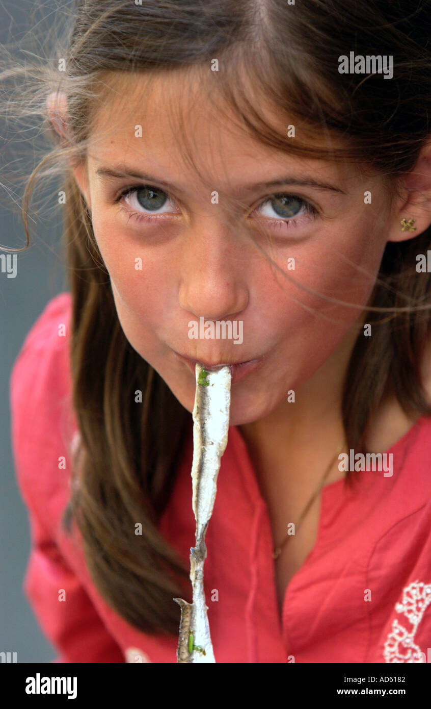 portrait of a young girl eating fish Stock Photo - Alamy