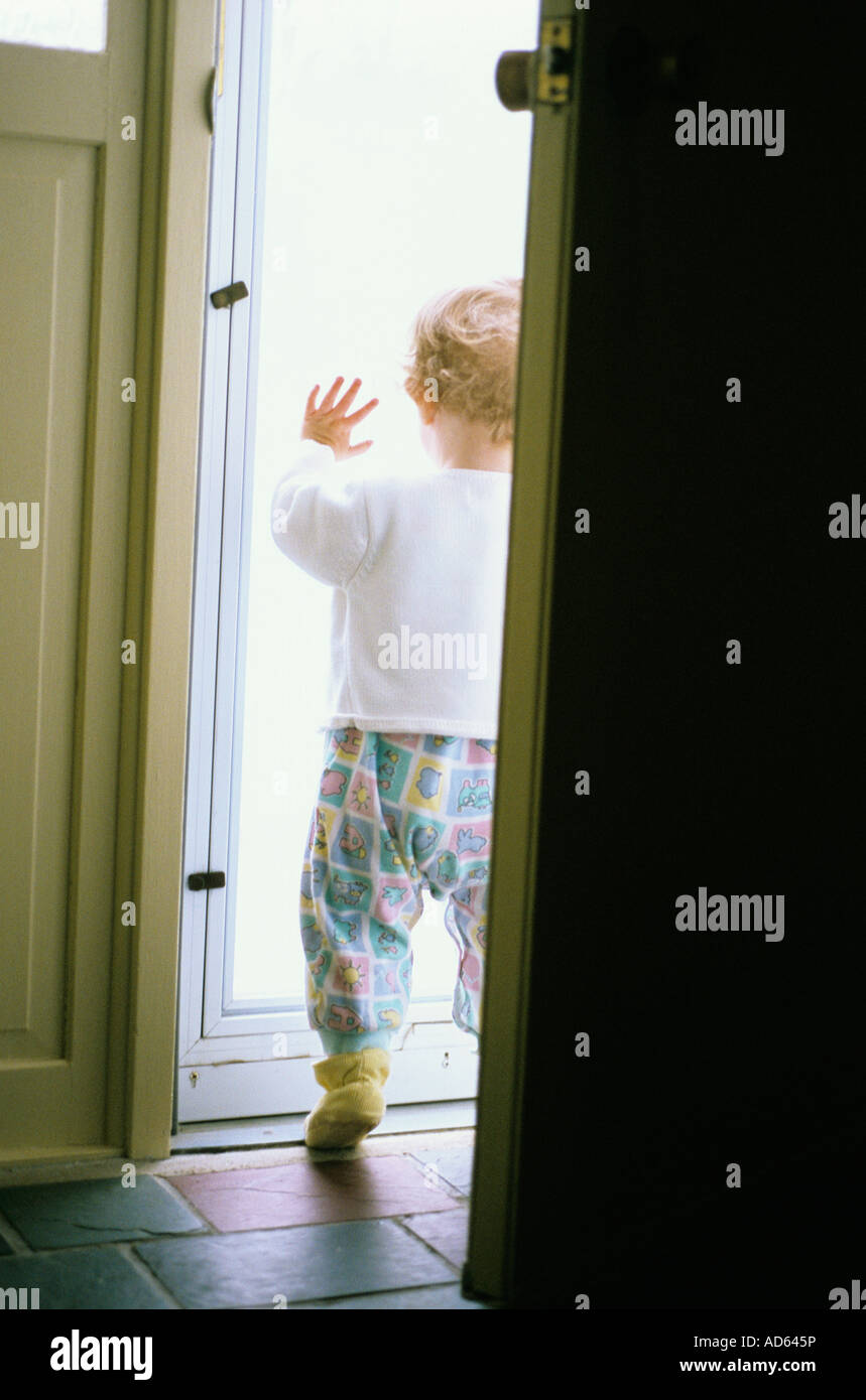Back view of toddler looking out front door Stock Photo - Alamy
