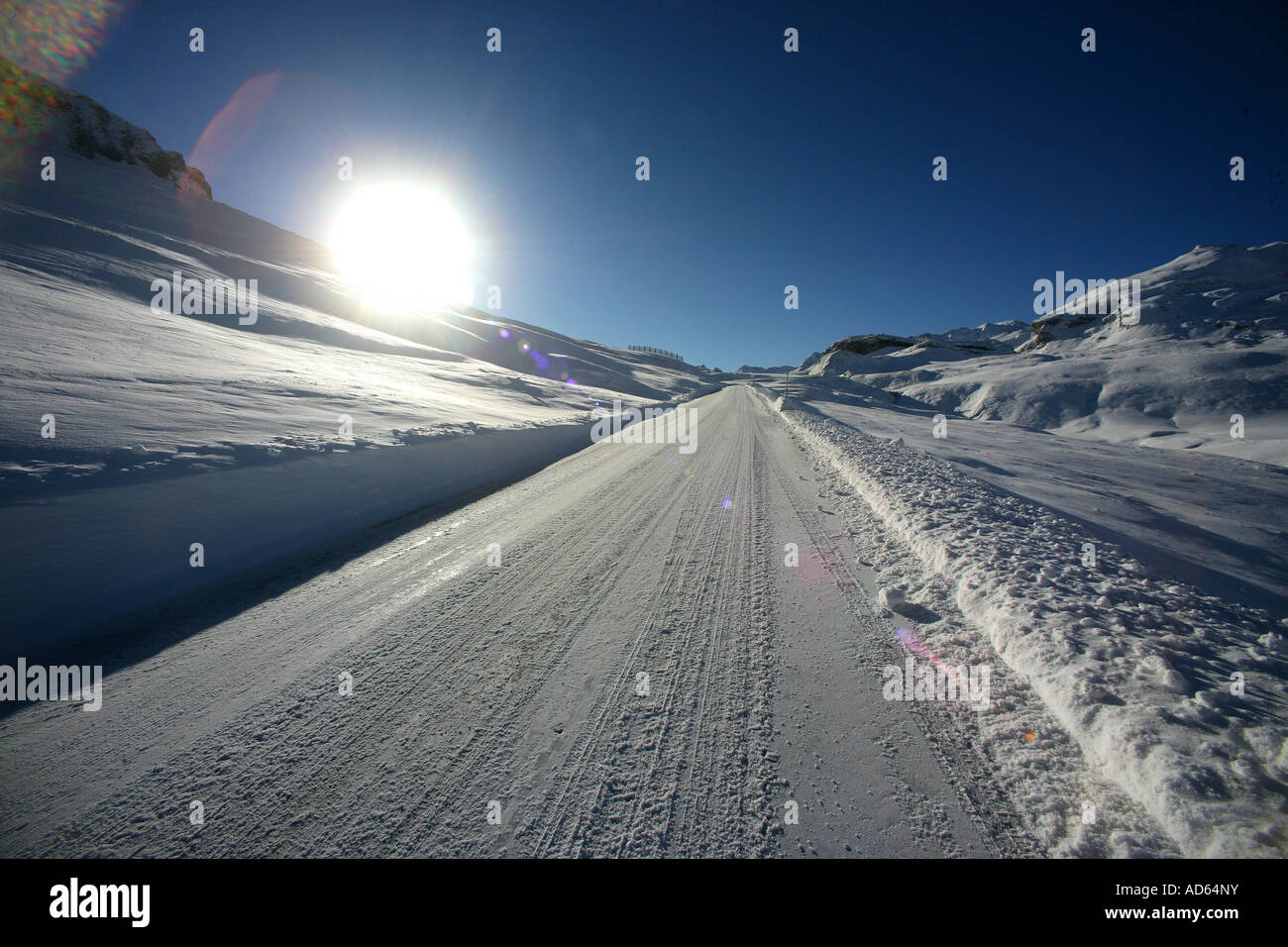 tracks in a a snowy road under the sunlight Stock Photo - Alamy