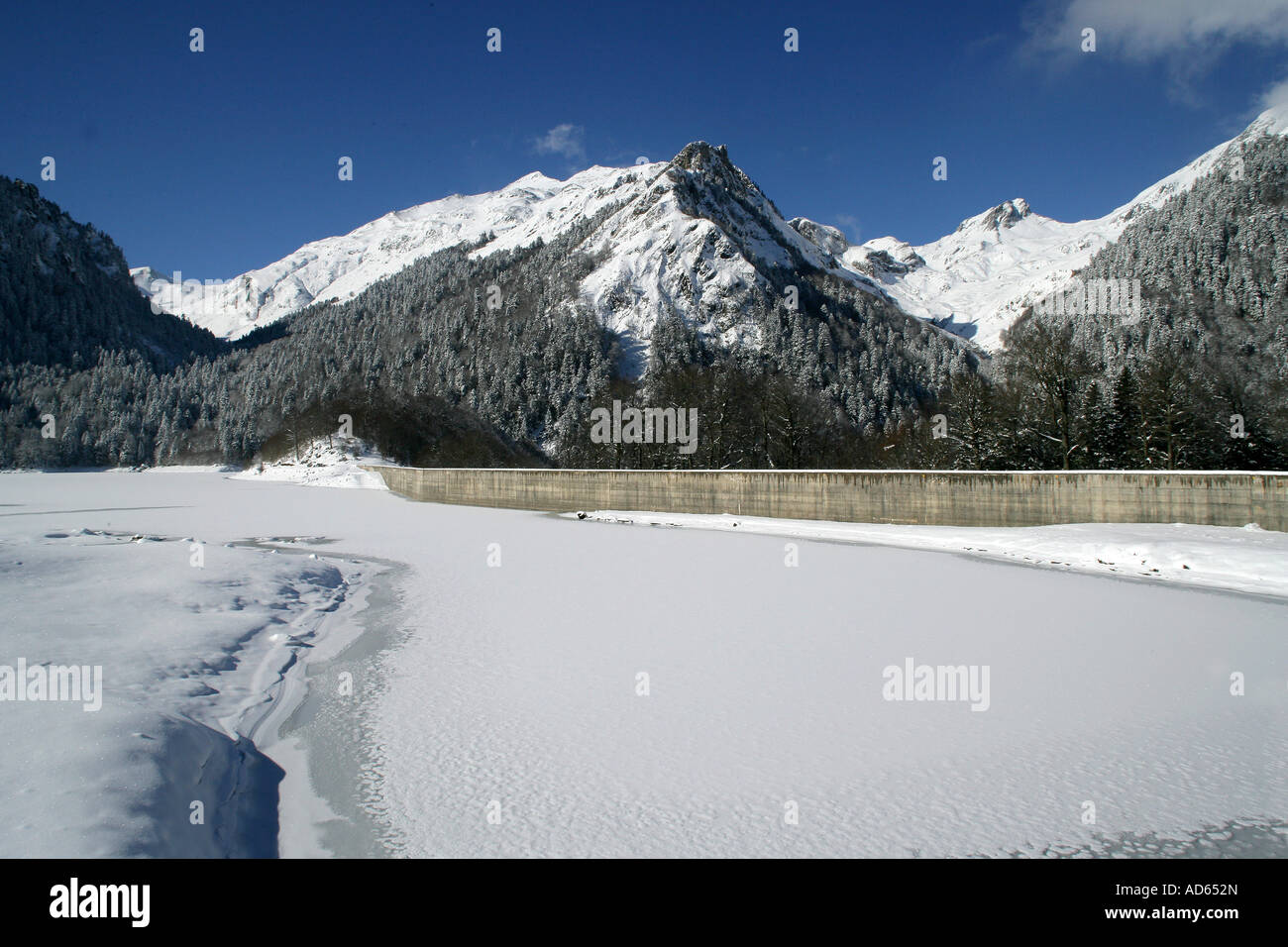 snow covered track or road crossing a tree covered mountain massif, a ...
