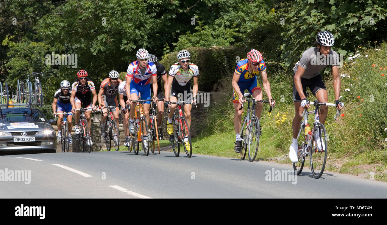 Cyclists in road race followed by support car Wales UK Stock Photo - Alamy