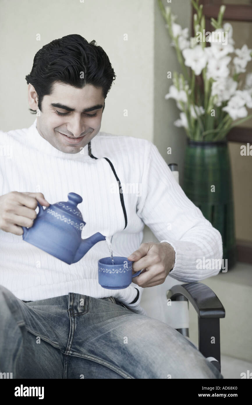 Close-up of a young man pouring tea into a tea cup Stock Photo - Alamy