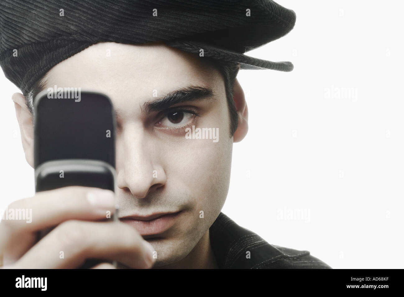 Portrait of a young man holding a mobile phone in front of his face ...