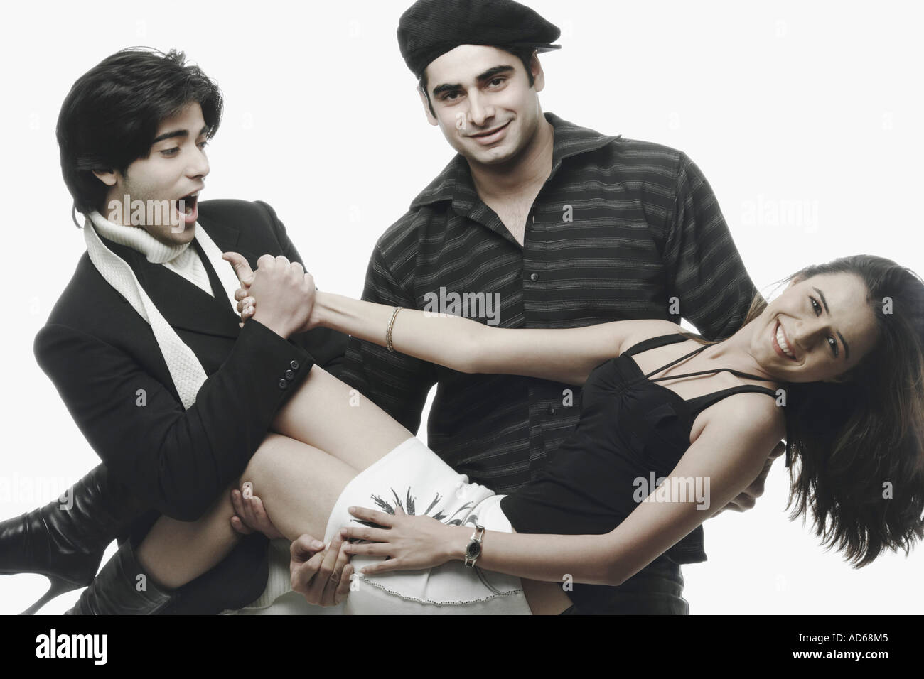 Two young men carrying a young woman Stock Photo - Alamy