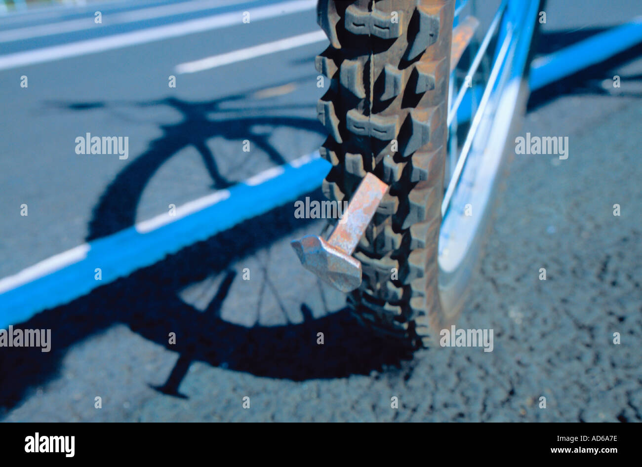 Huge spike pierces Tyre of bicycle wheel Stock Photo - Alamy