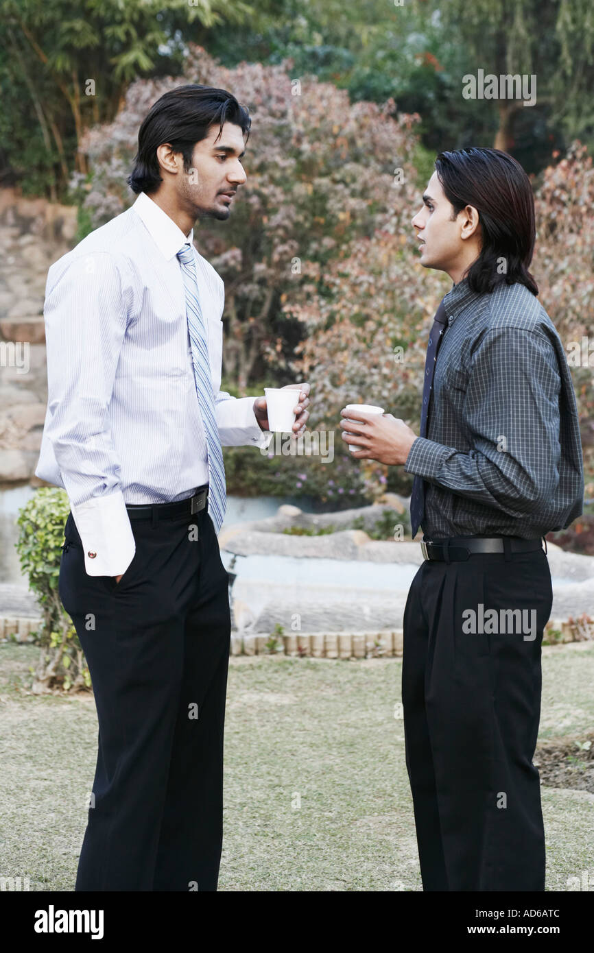 Side profile of two businessmen talking in the garden Stock Photo - Alamy