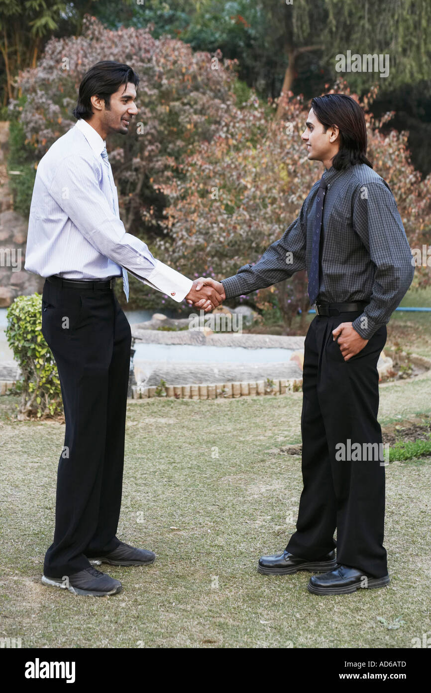 Side profile of two businessmen shaking hands Stock Photo - Alamy