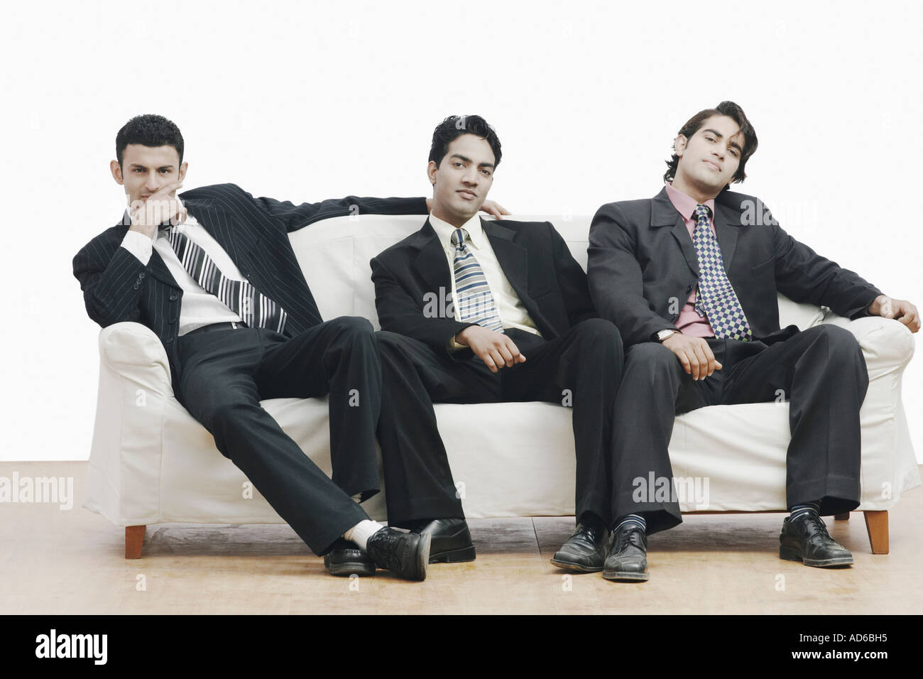 Portrait of three businessmen sitting on a couch Stock Photo - Alamy