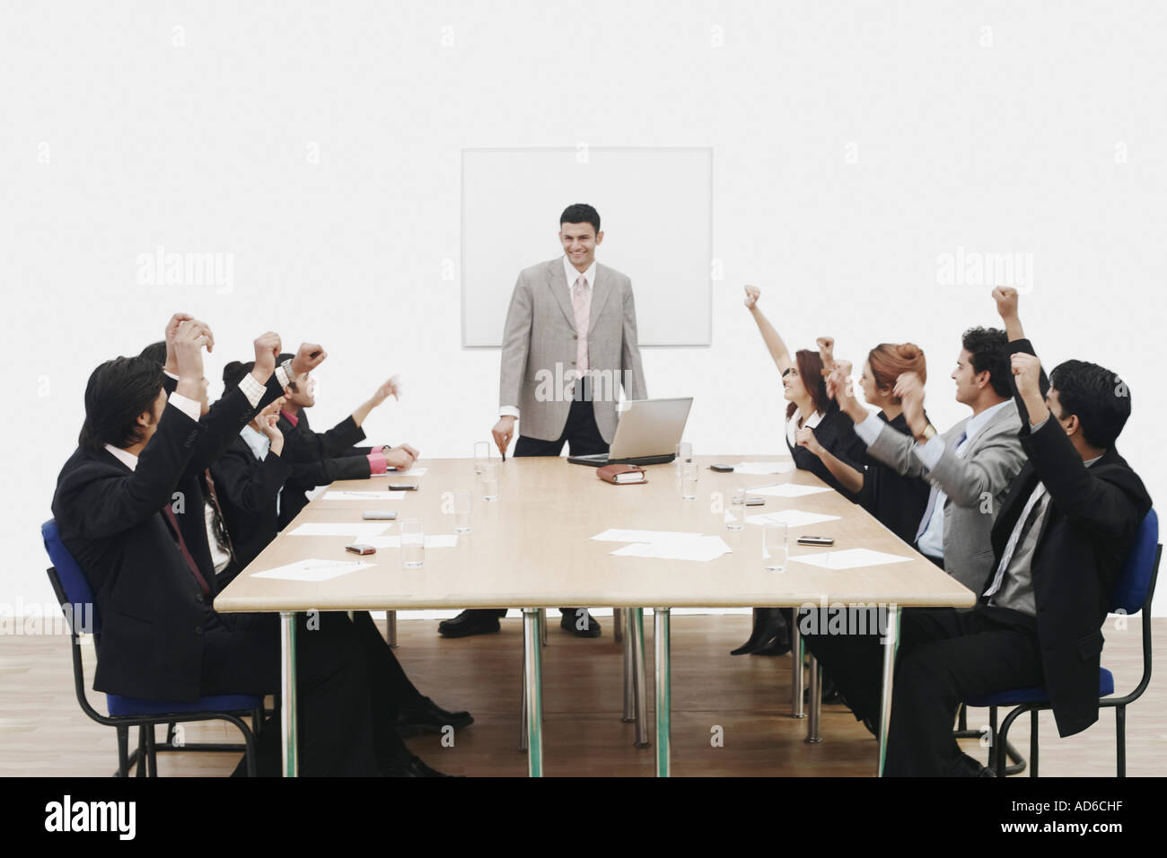 Group of business executives raising their hands at a presentation ...