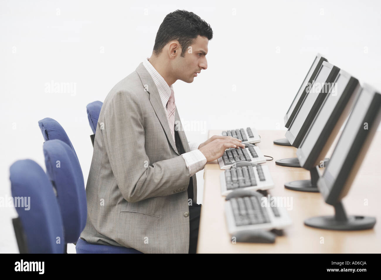 Side profile of a businessman sitting in front of a computer Stock ...