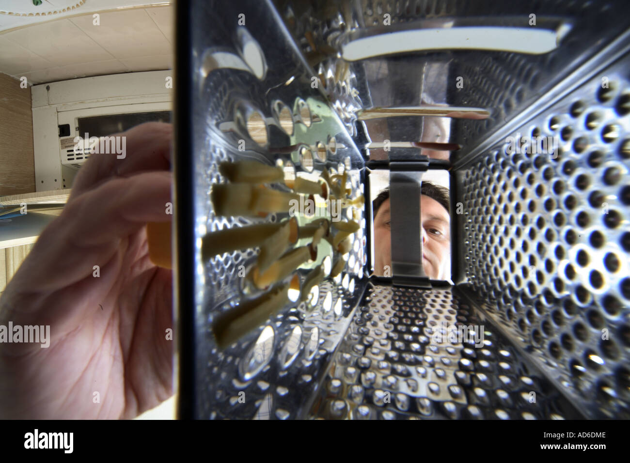 Unusual angle upshot of a man grating cheese with a cheese grater Stock ...