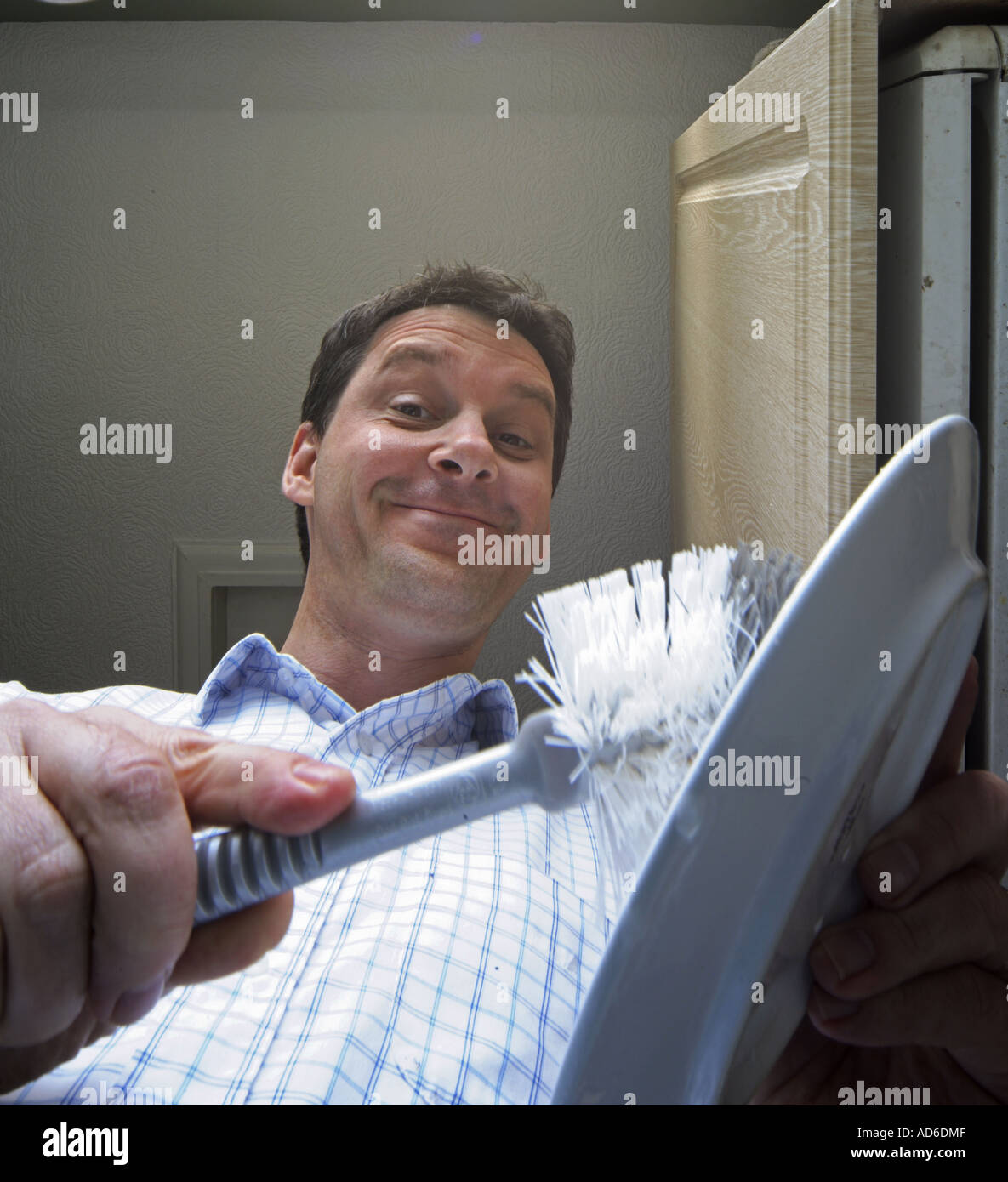 Unusual angle upshot of a man looking happy washing the pots at the ...