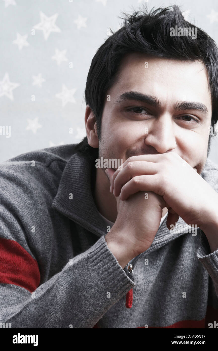 Portrait of a young man covering his mouth with his hands Stock Photo ...