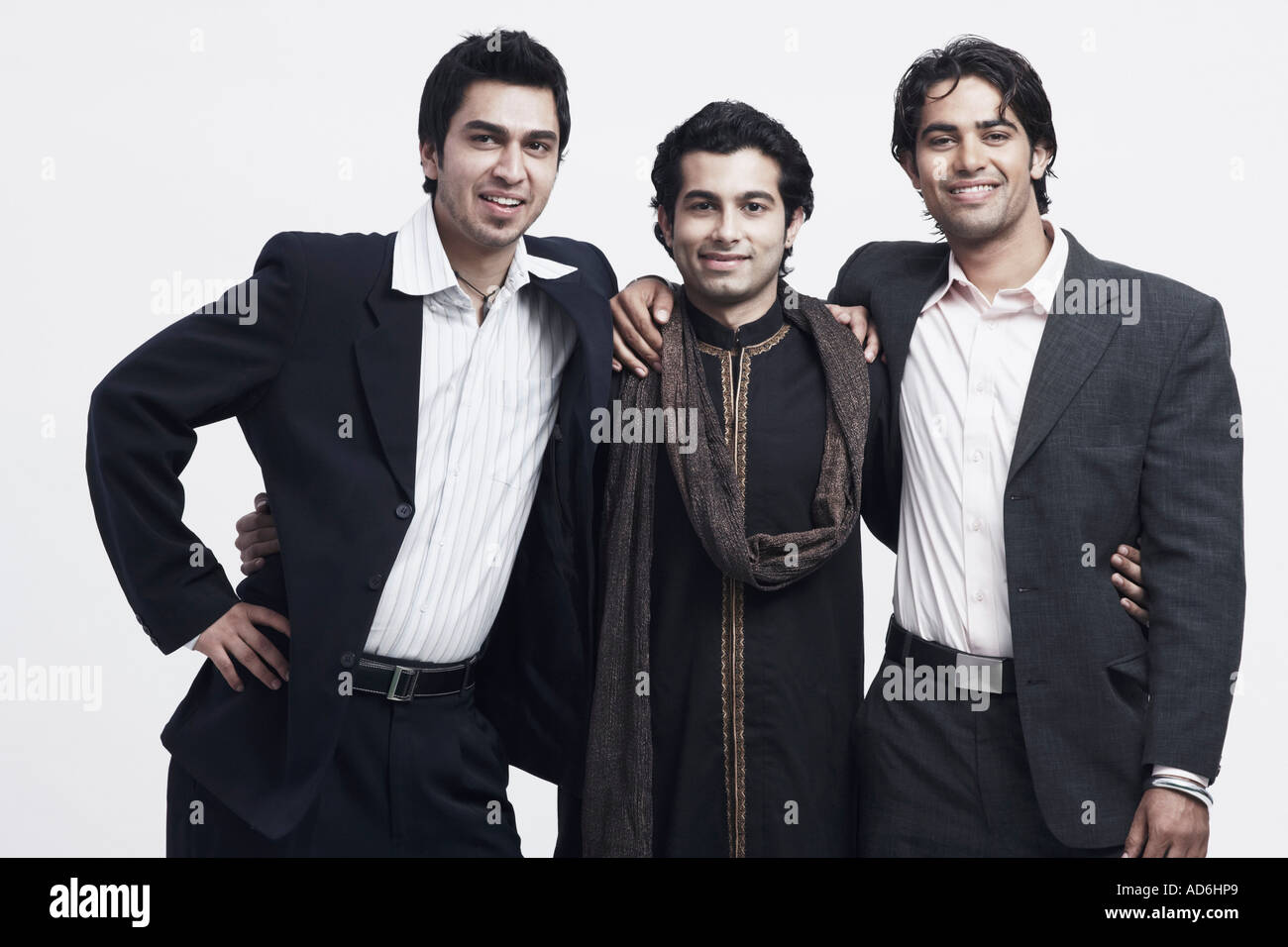 Portrait of three young men standing with their arms around each other ...