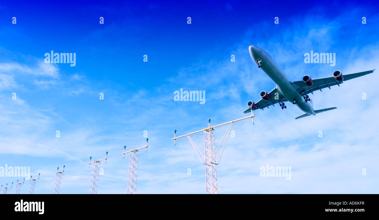 Low angle view of commercial aircraft flying over approach lights Stock ...