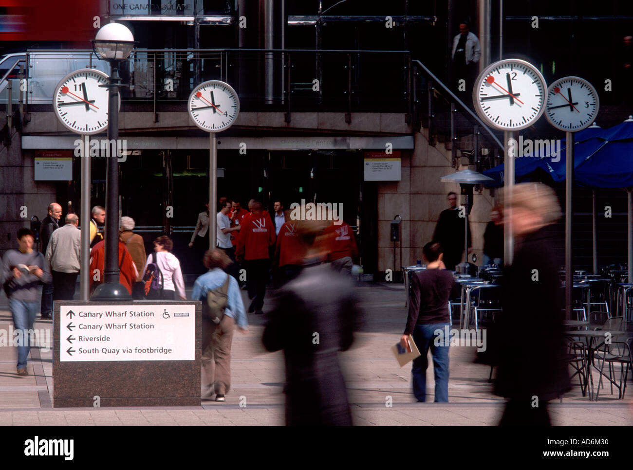 Lollipop clocks and people in blurred motion before One Canada Square ...