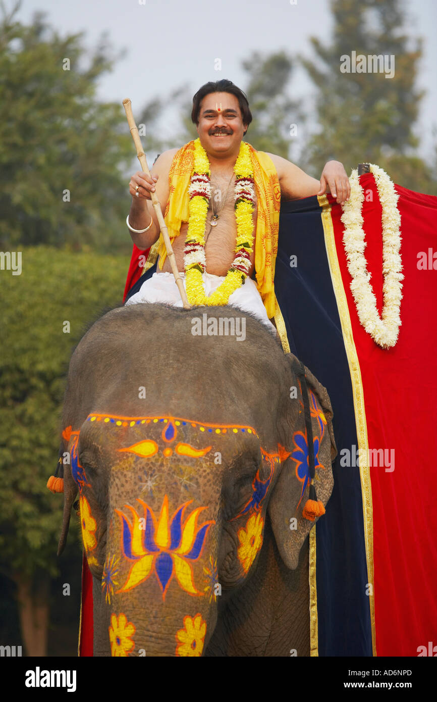 Portrait of a priest riding an elephant Stock Photo - Alamy