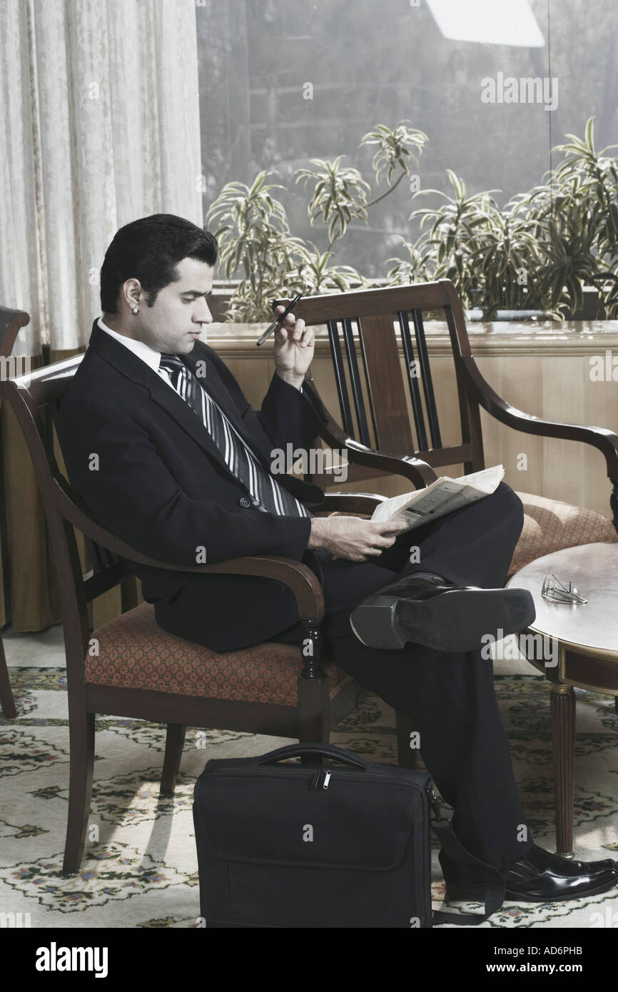 Side profile of a businessman reading a newspaper Stock Photo - Alamy