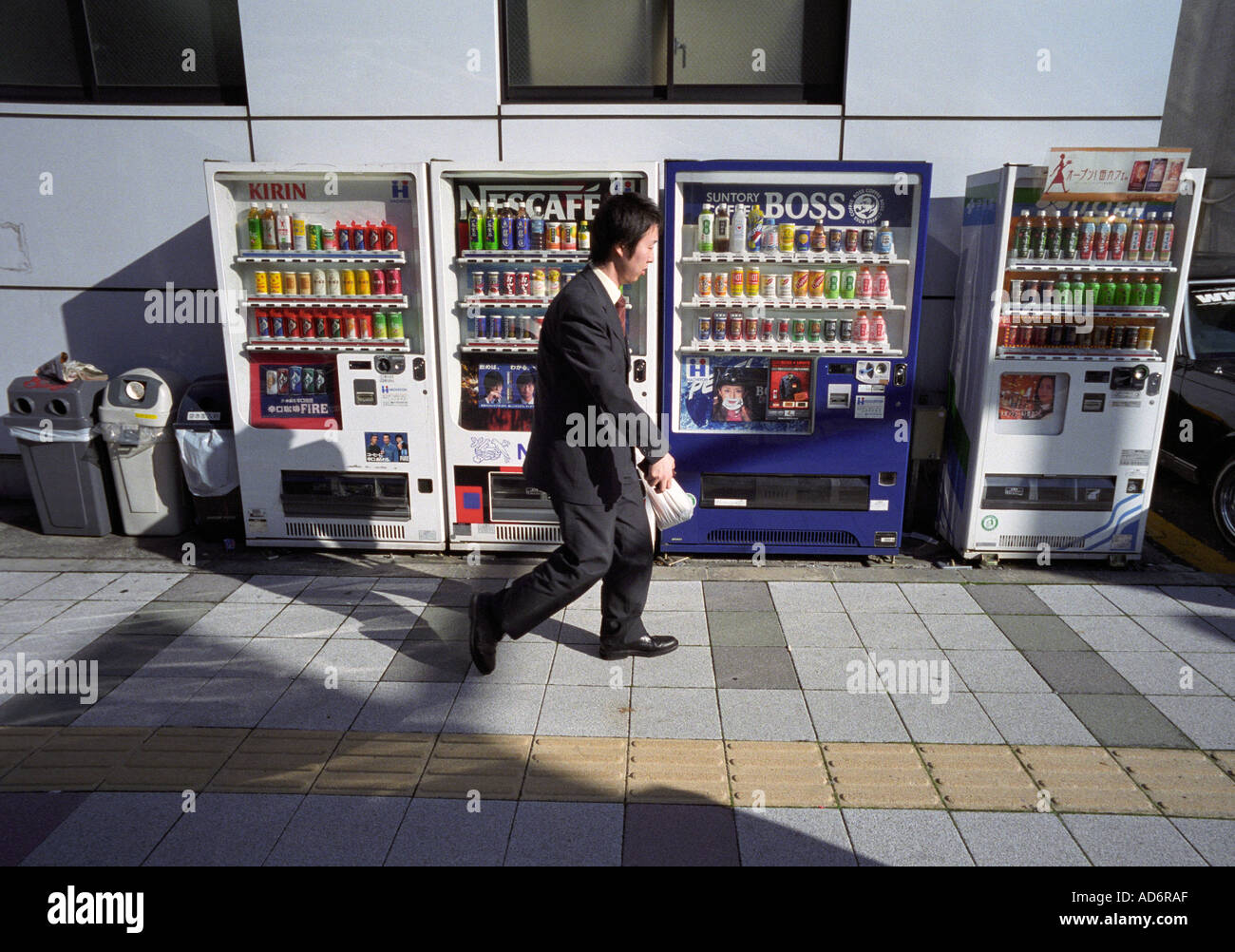 A man in Tokyo passes by drink vending machines omnipresent all over ...