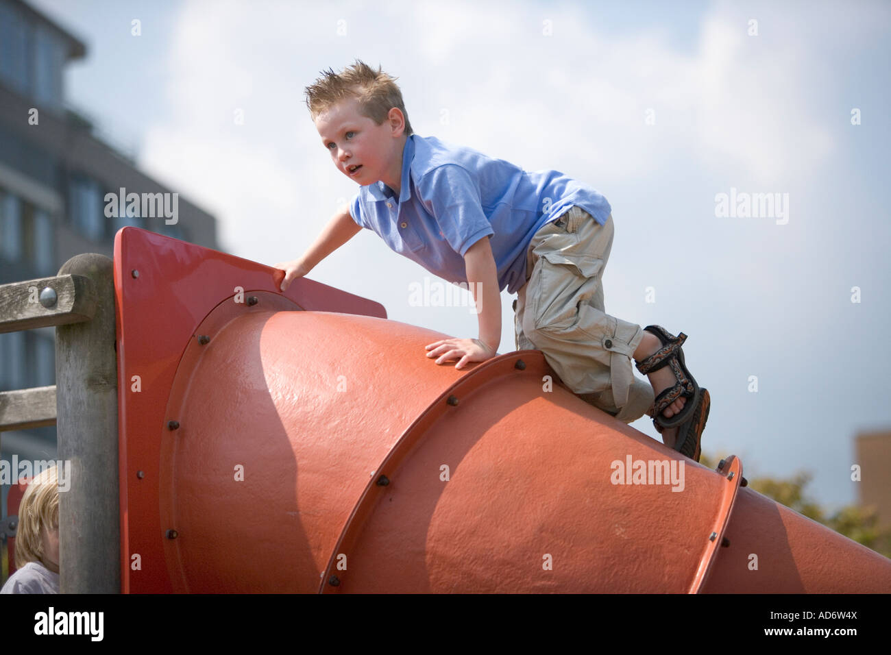 Boy climbing on an iron pipe at the playground Stock Photo - Alamy