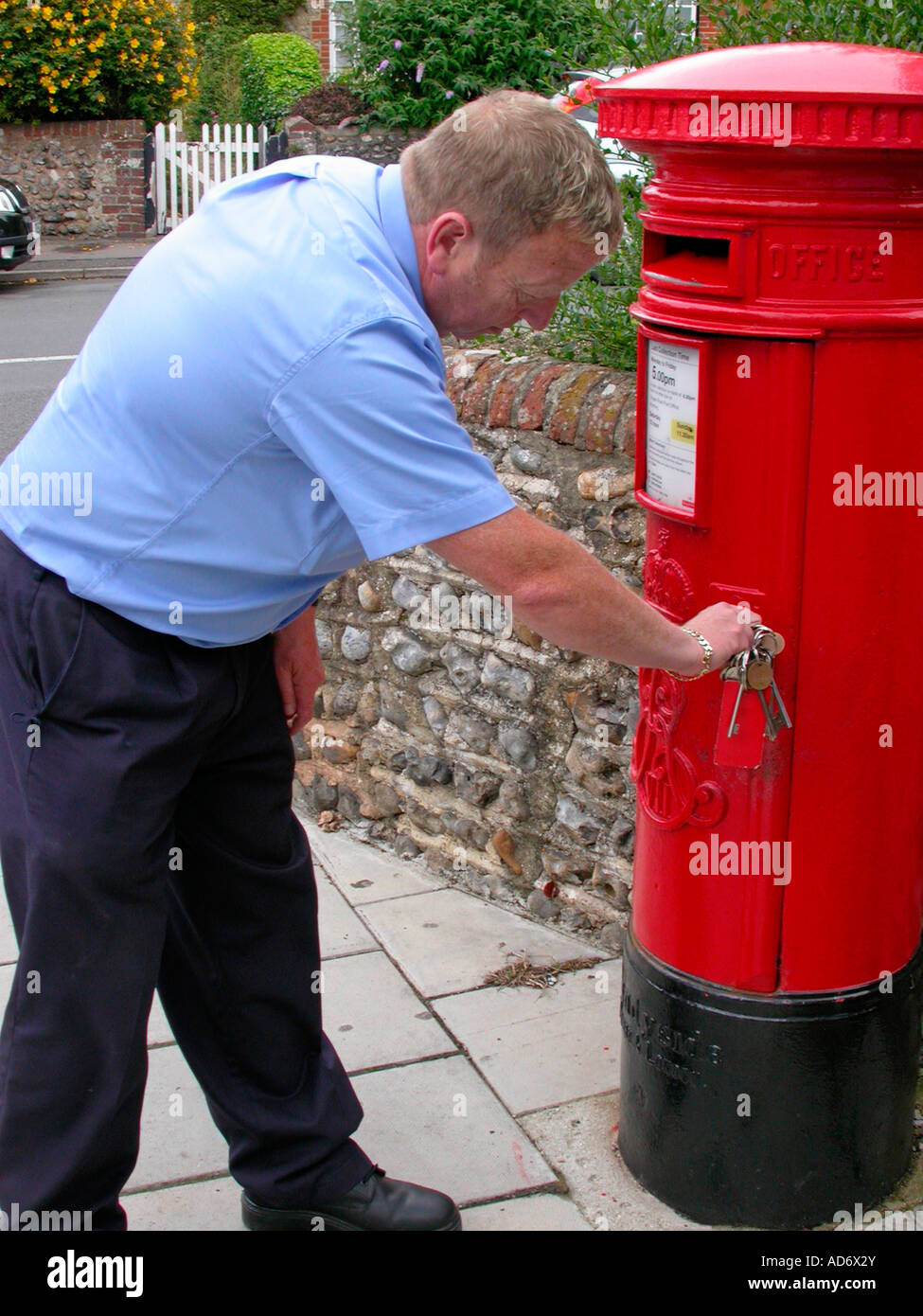 postman emptying letter box Stock Photo - Alamy
