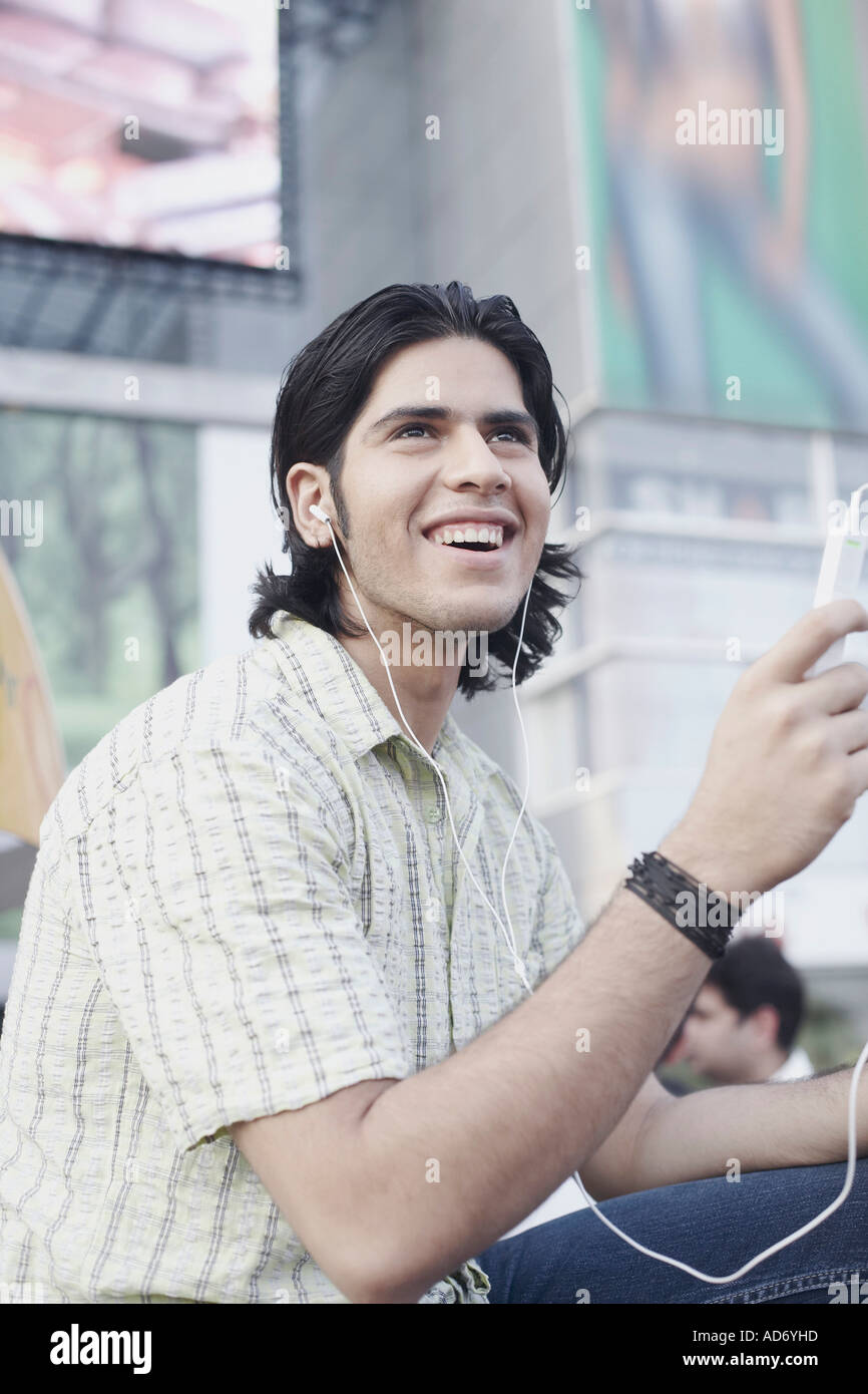 Side profile of a young man listening to an MP3 player Stock Photo - Alamy