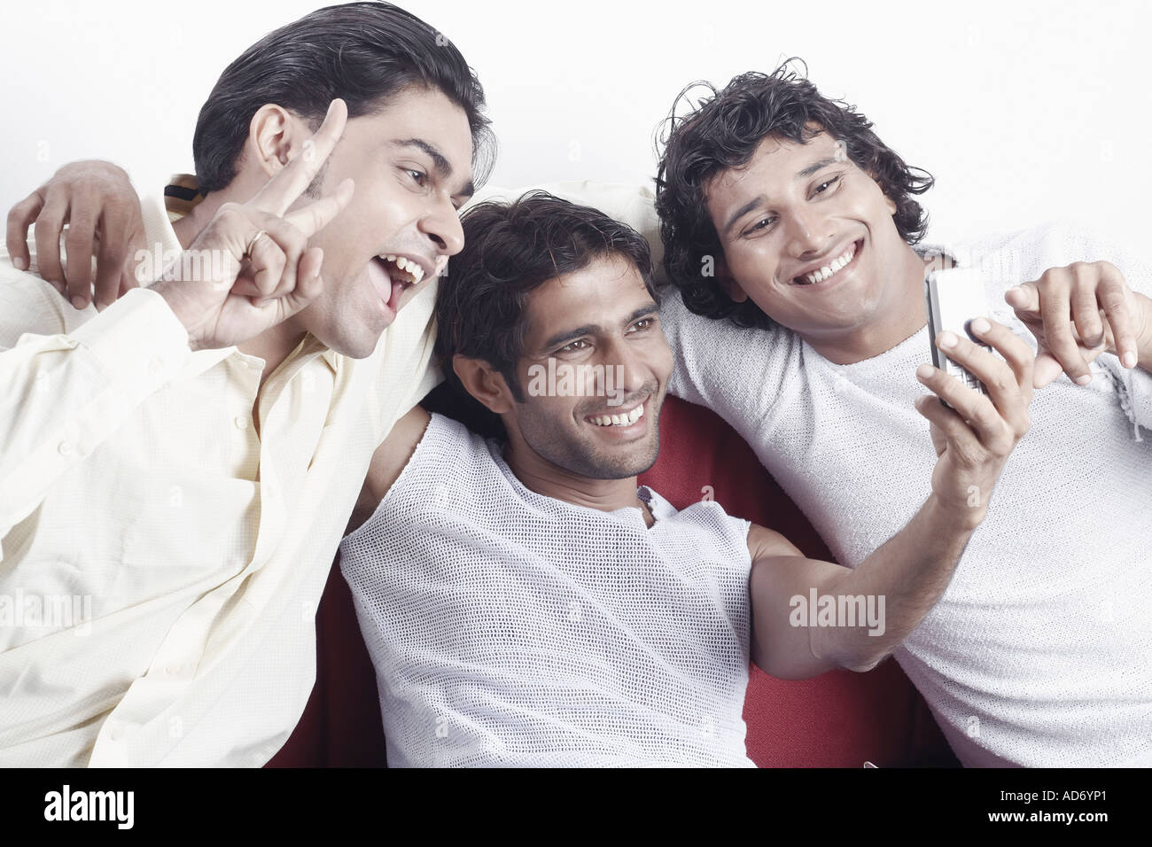 Three young men looking at a mobile phone Stock Photo - Alamy