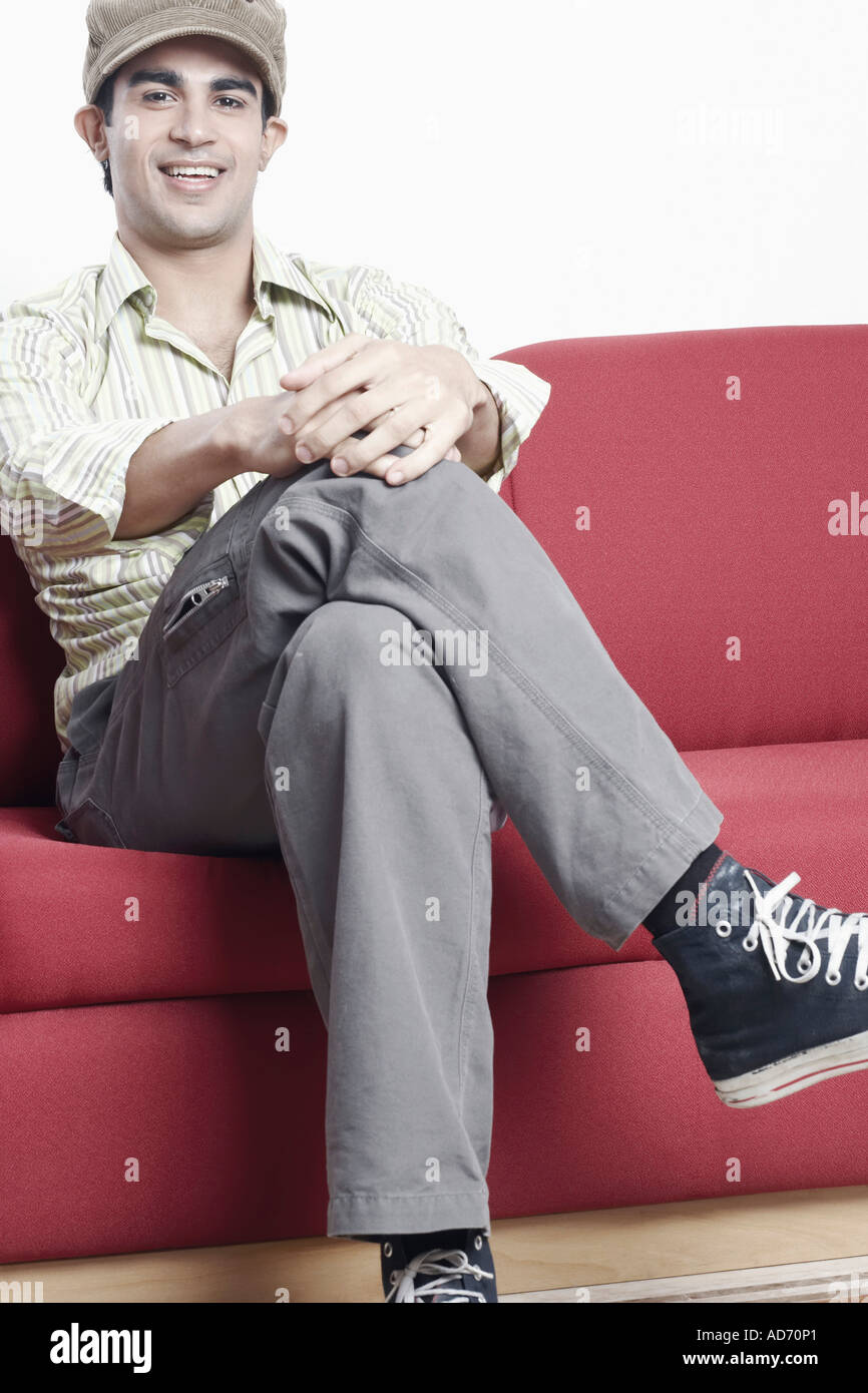 Portrait of a young man sitting on a couch Stock Photo - Alamy