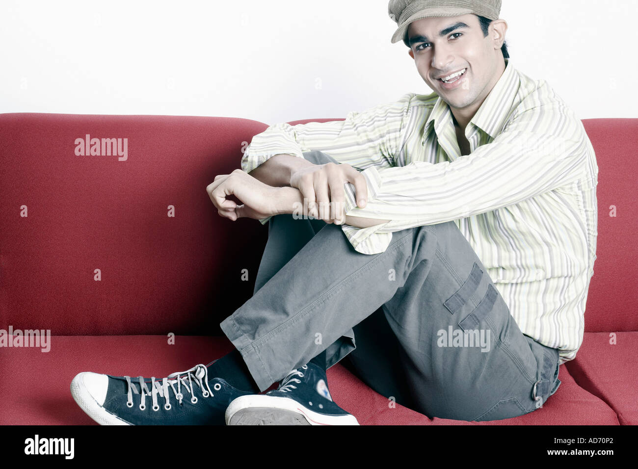 Portrait of a young man sitting on a couch Stock Photo - Alamy