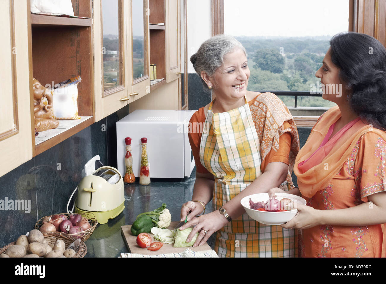 Two women talking in the kitchen Stock Photo - Alamy