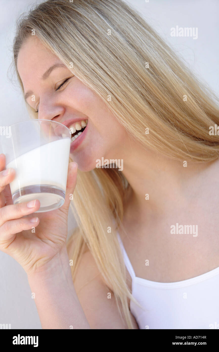 Young blond woman drinking glass of milk, laughing, close up Stock ...
