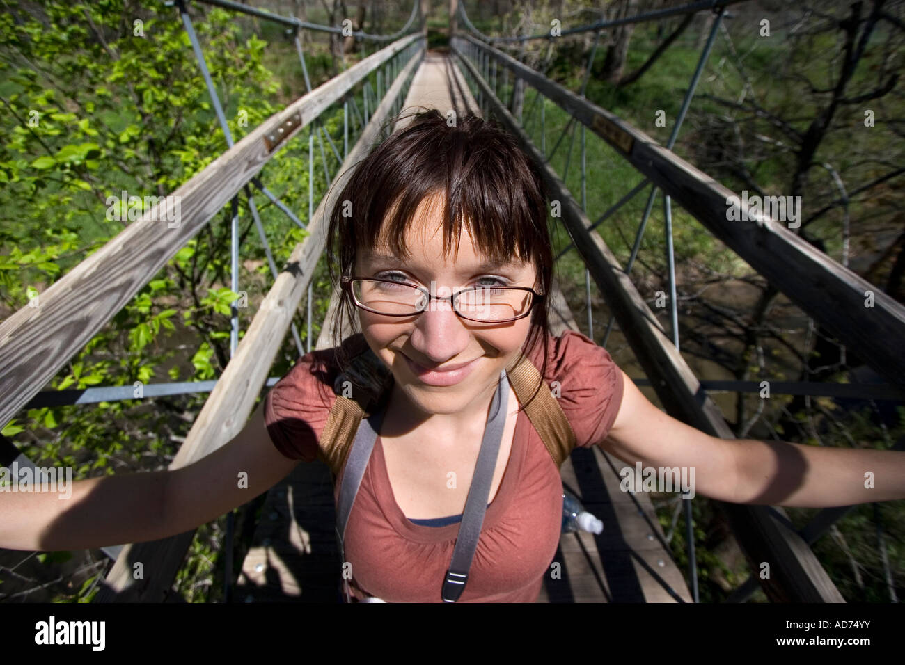 A caucasian woman on a long footpath suspension bridge Stock Photo - Alamy