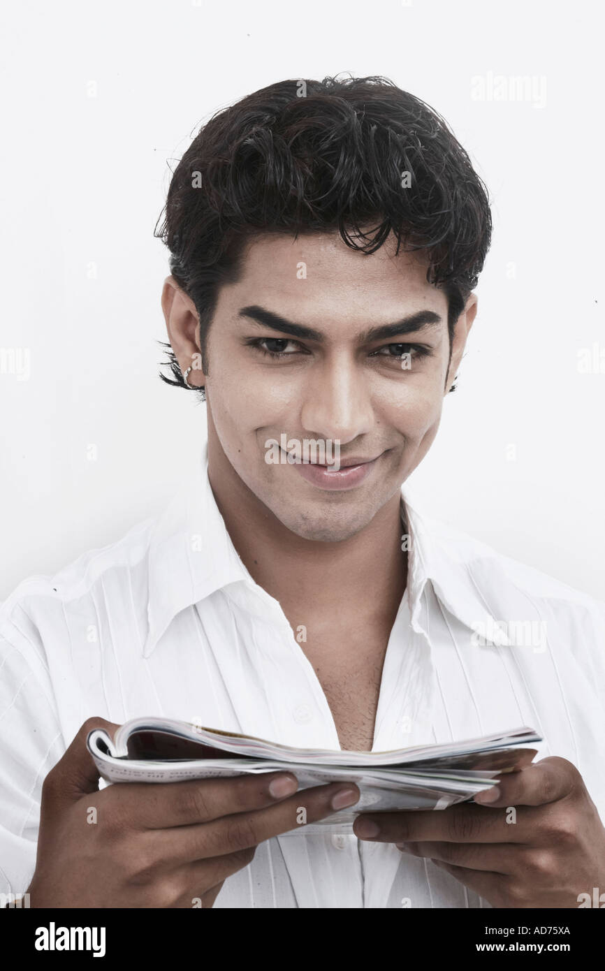 Portrait of a young man holding a magazine Stock Photo - Alamy